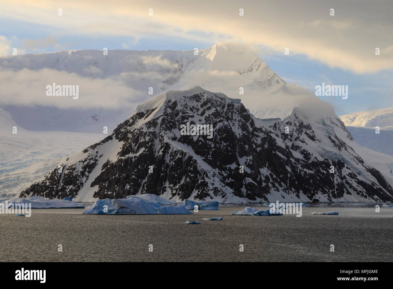 Sunrise, with atmospheric cloud and mist, mountains, glaciers and ...