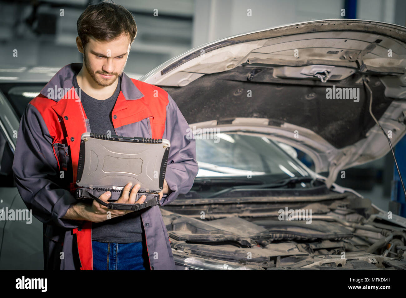 mechanic using special laptop computer to check car engine Stock Photo ...