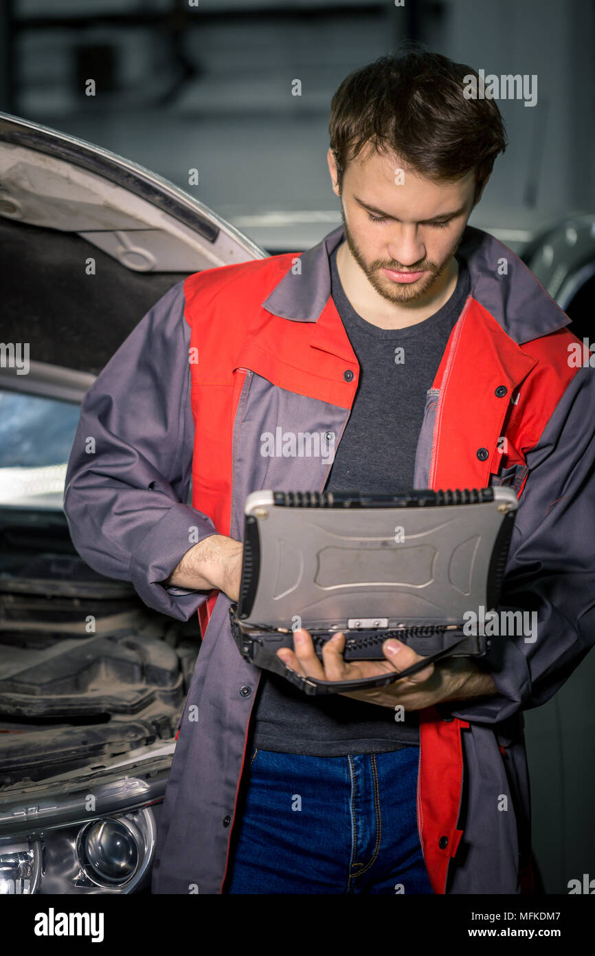 mechanic using special laptop computer to check car engine Stock Photo ...
