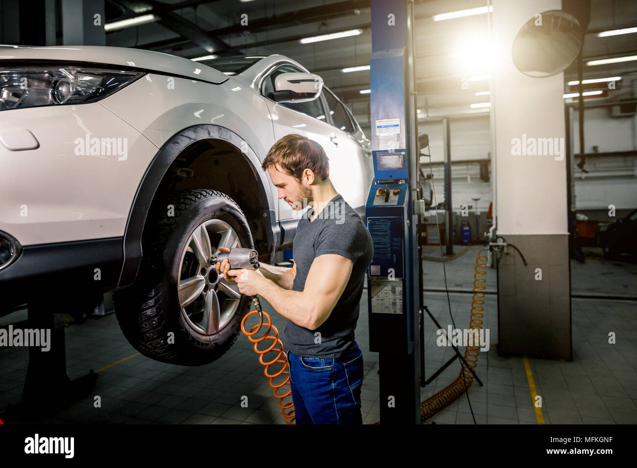 Mechanic removing wheel hi-res stock photography and images - Alamy