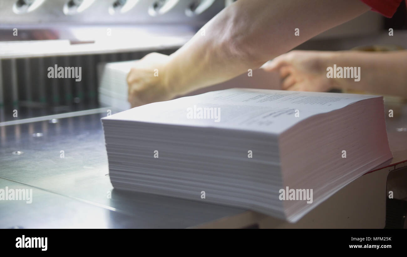 Female worker folds a stack of paper in the typography Stock Photo - Alamy
