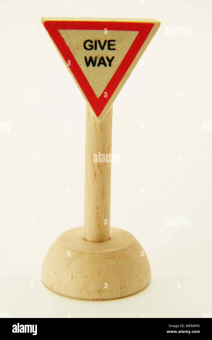 A straight on view of a simple wooden toy road sign showing Give Way ...