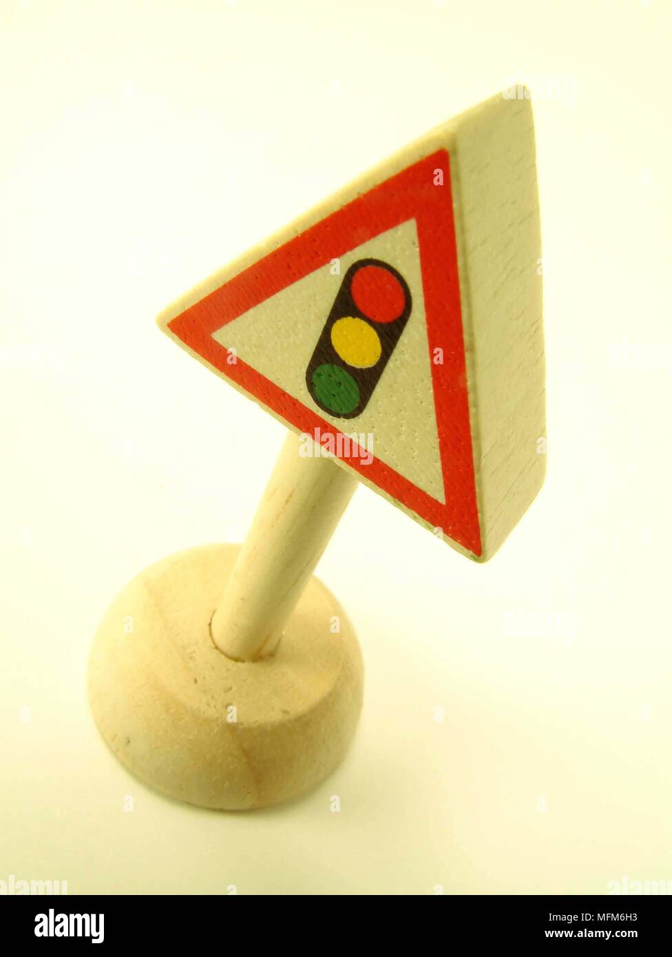 A high dramatic side view of a simple wooden toy road sign warning of ...