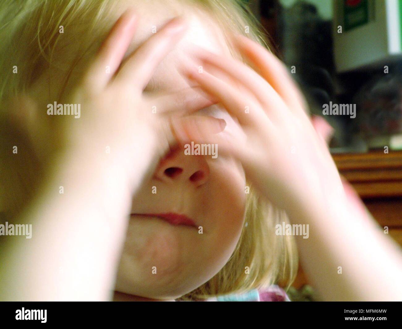 Young child hiding it's face upset and crying alone in a room after ...