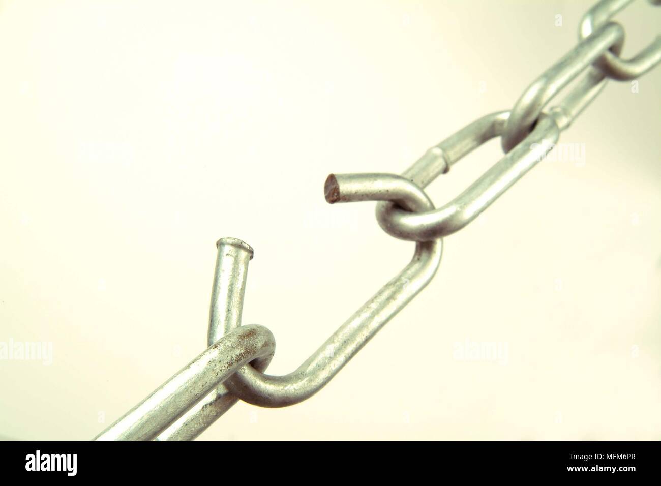 Strong heavy duty steel chain under tension with a broken and stretched ...