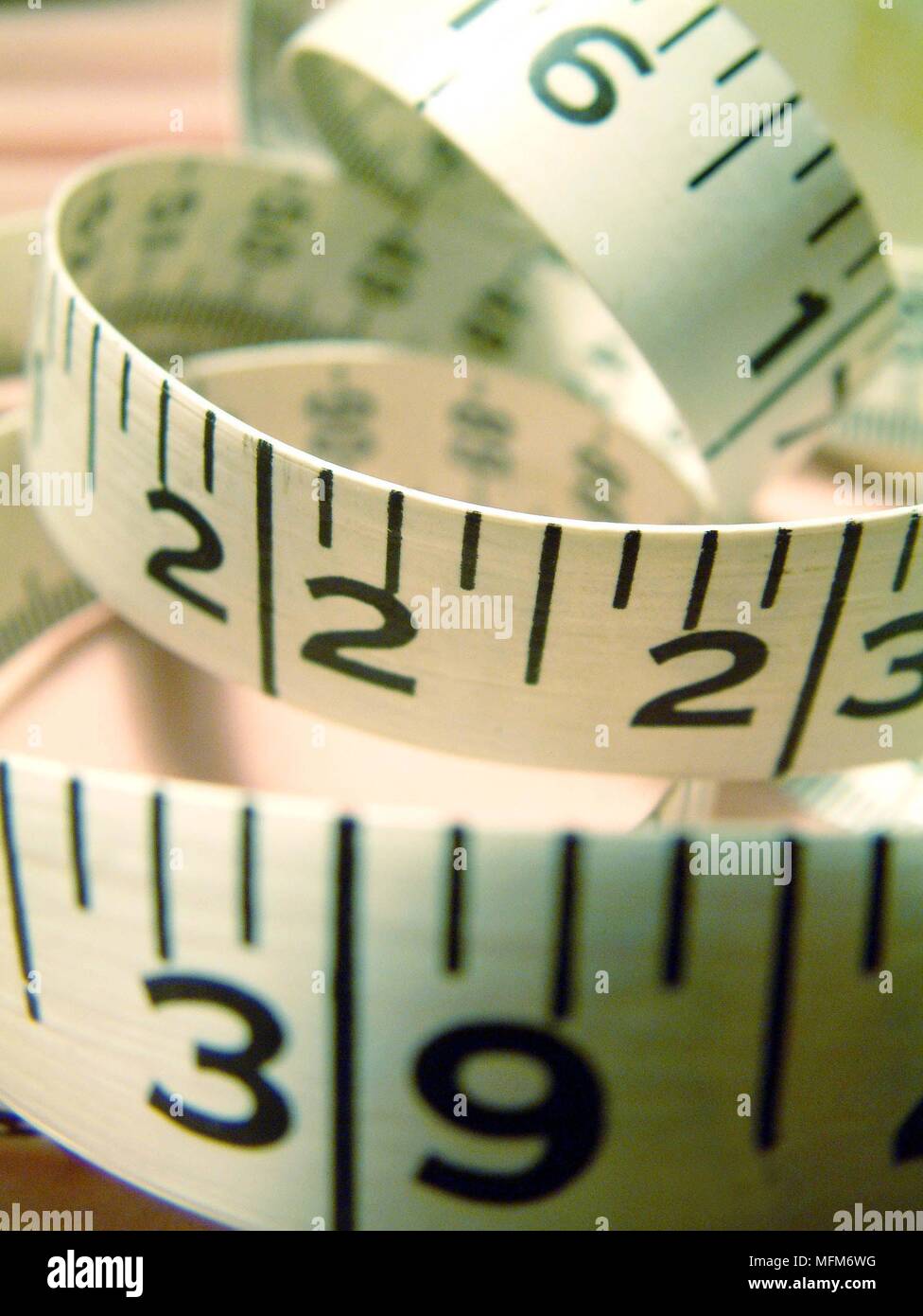 Dress makers tape measure uncoiled and spiralling across the picture ...