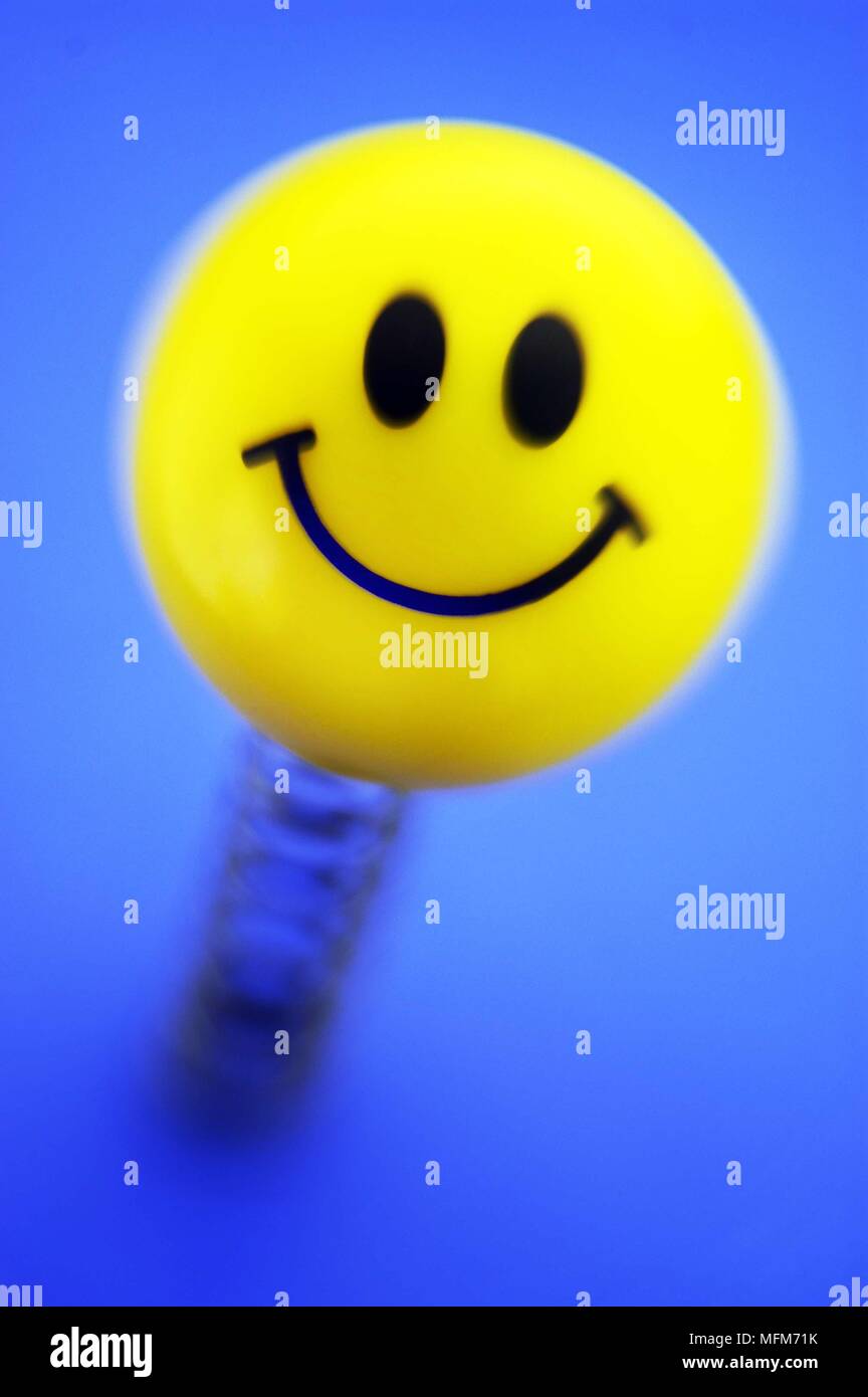 A happy smiling face painted on a yellow rubber ball ready to bounce ...