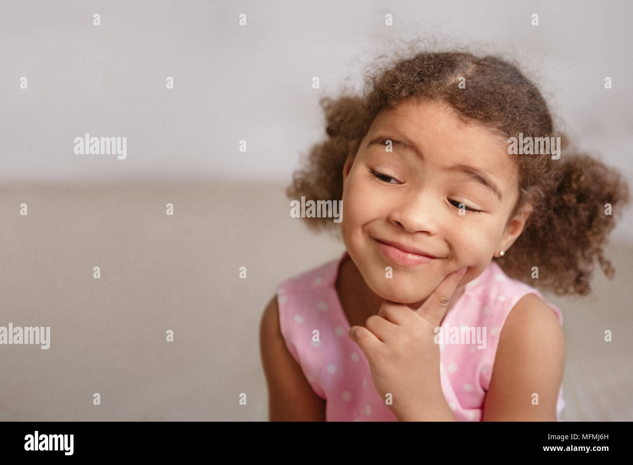 Fun confused kid girl thinking and looking serious about on pink ...