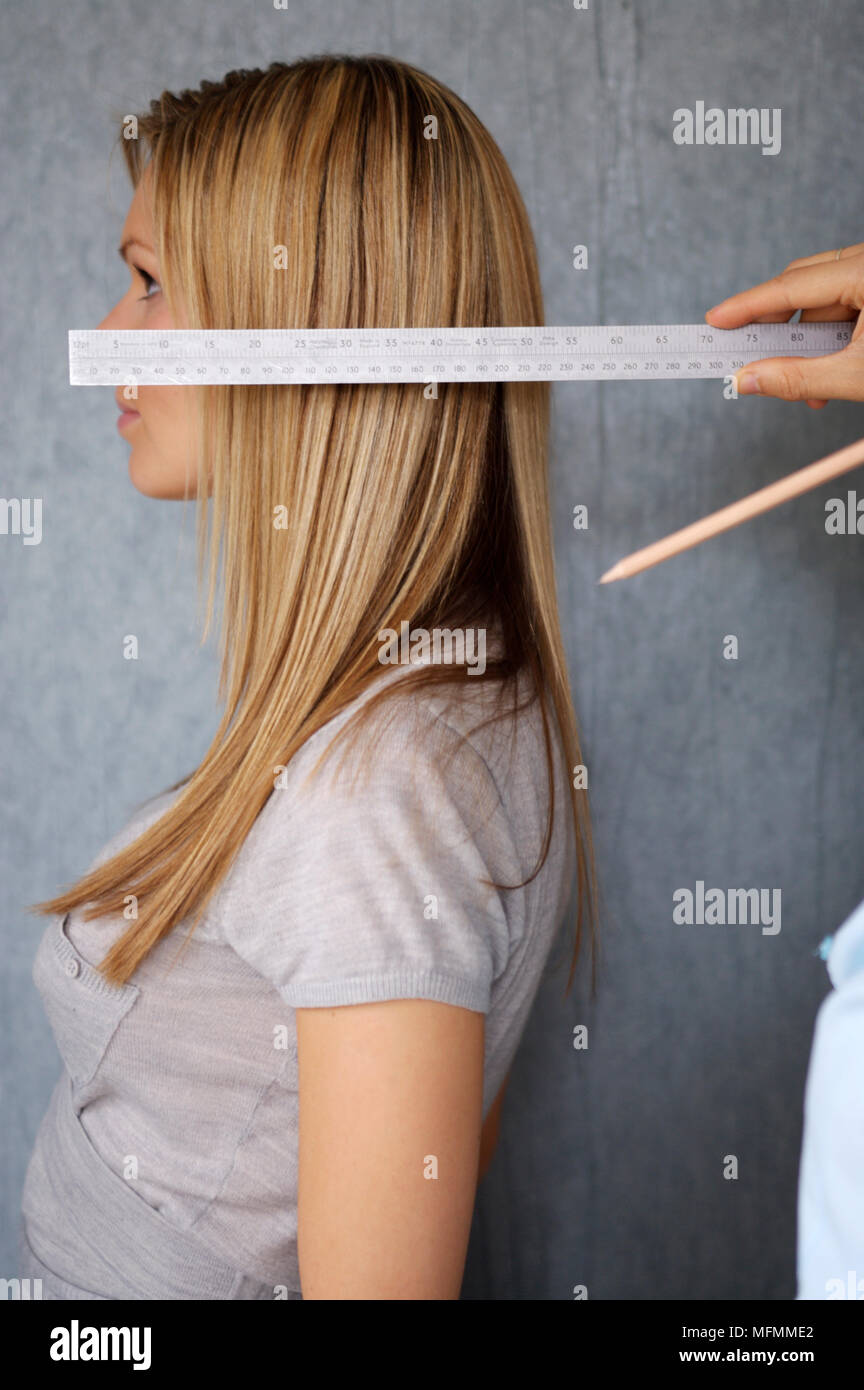 Close-up of a person's hand measuring a young woman's hair Ref: CRB413 ...