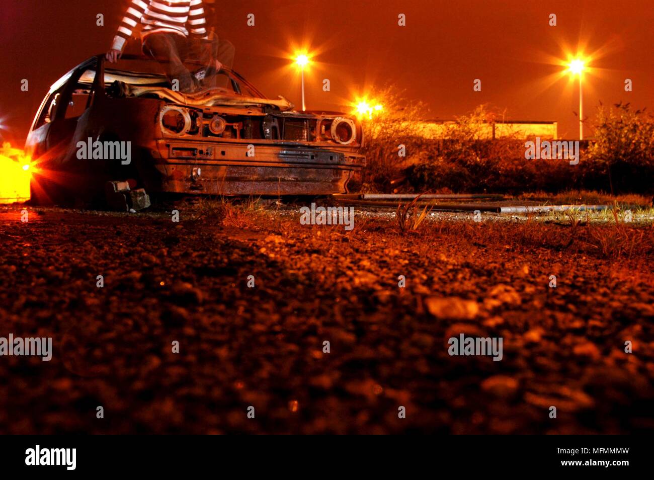 Man sitting on a demolished car at night Ref: CRB416 10009 024 ...