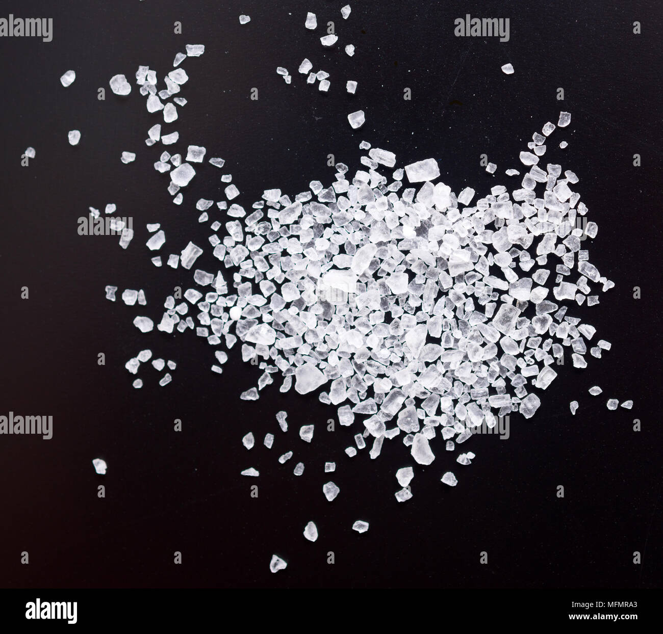 Salt on black background Stock Photo - Alamy
