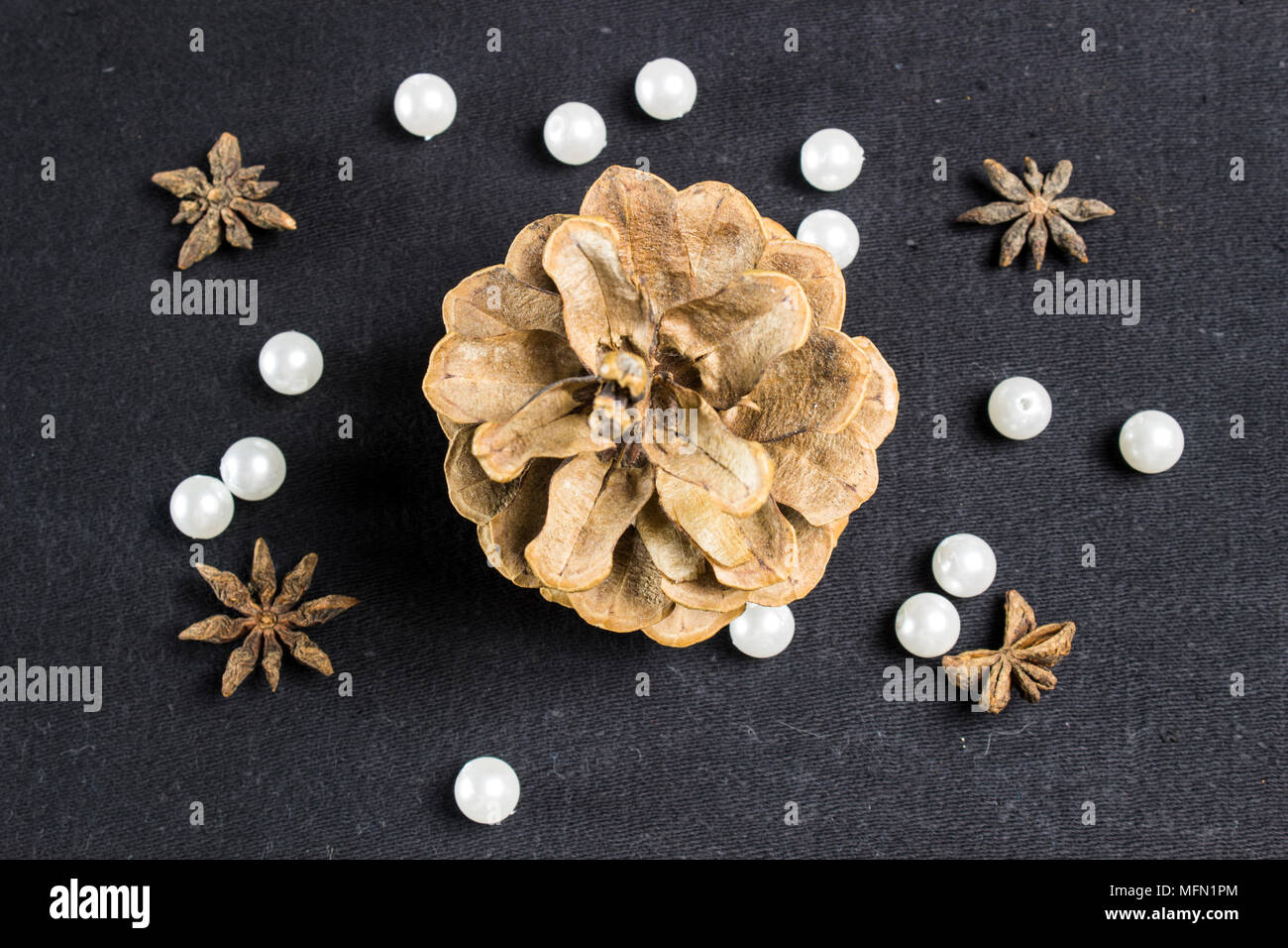 Pine cone and white pearls on dark black background christmas ...