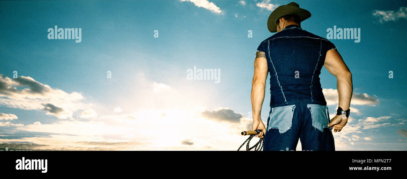 Rear view of a cowboy standing and holding a lasso Ref: CRB342 10012 ...