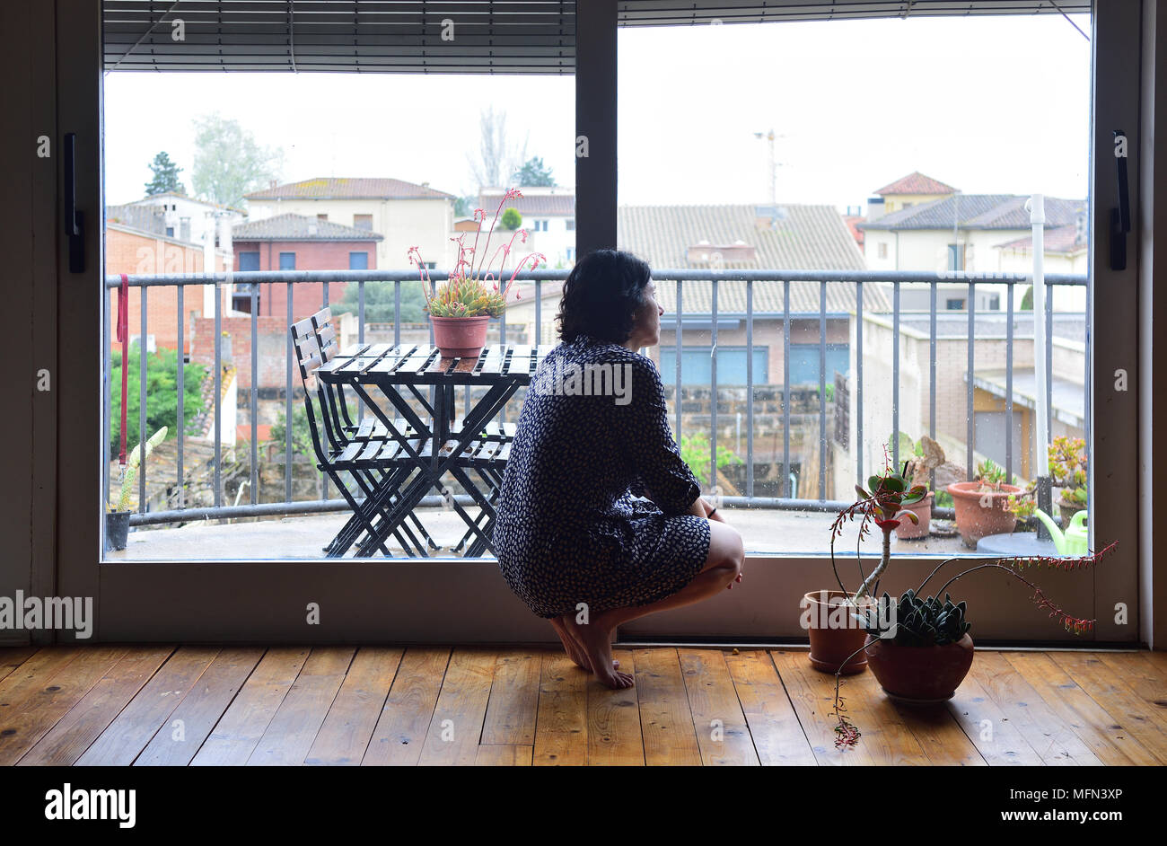 a sad woman looking out the window at home Stock Photo - Alamy