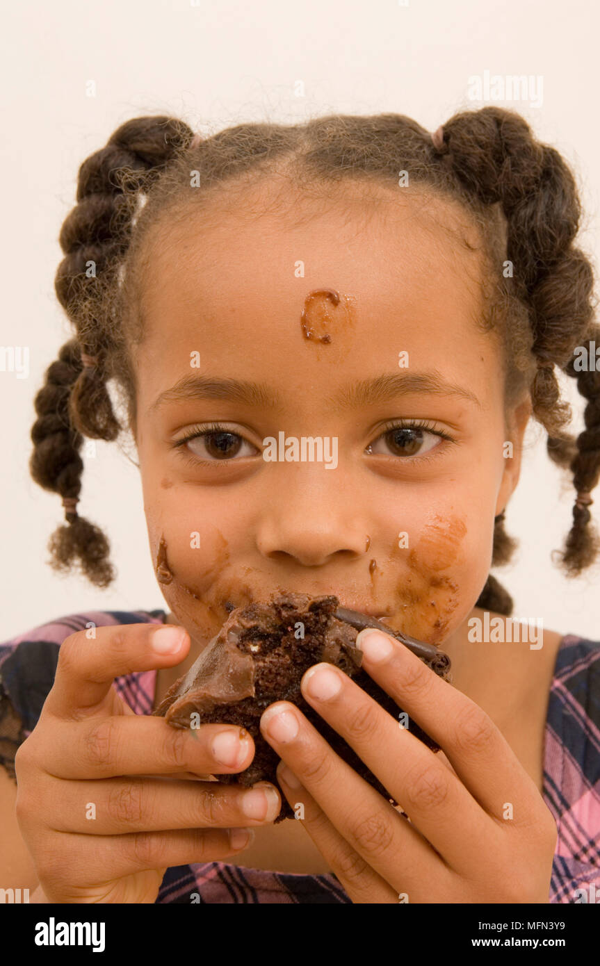 Portrait of a girl eating a chocolate cake Ref: Compulsory Credit Stock ...