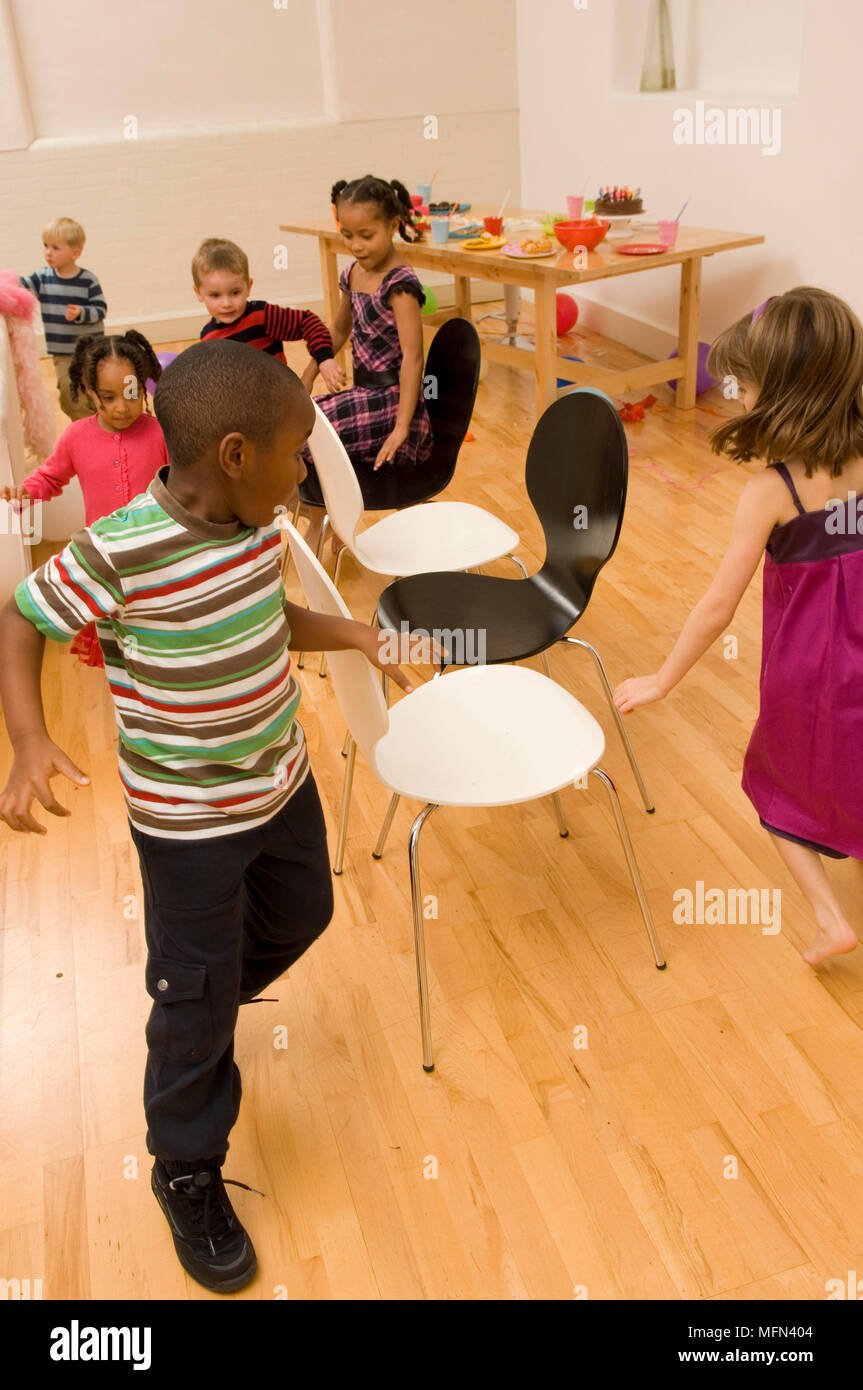 Children running around chairs hi-res stock photography and images - Alamy