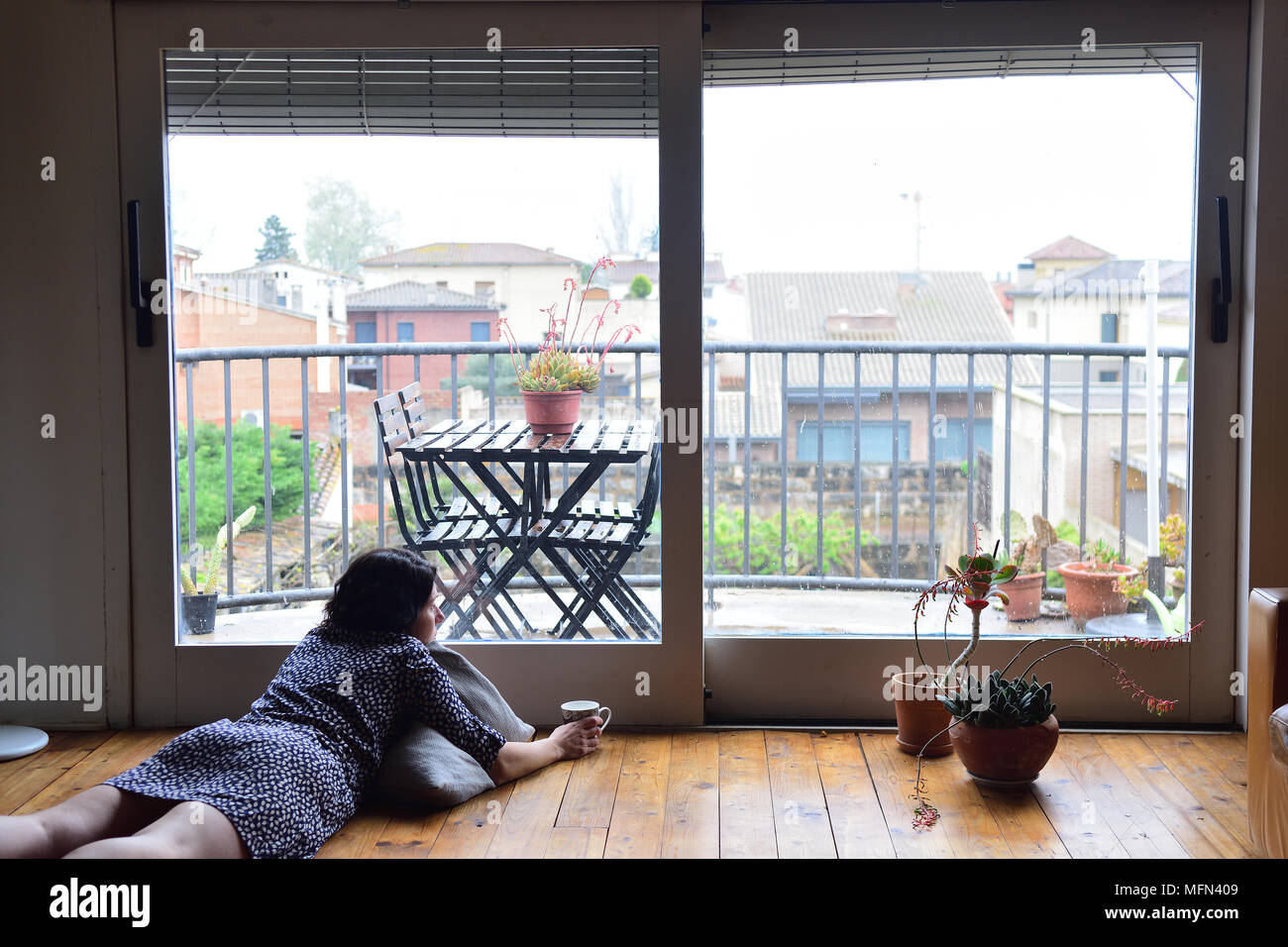 a sad woman looking out the window at home Stock Photo - Alamy