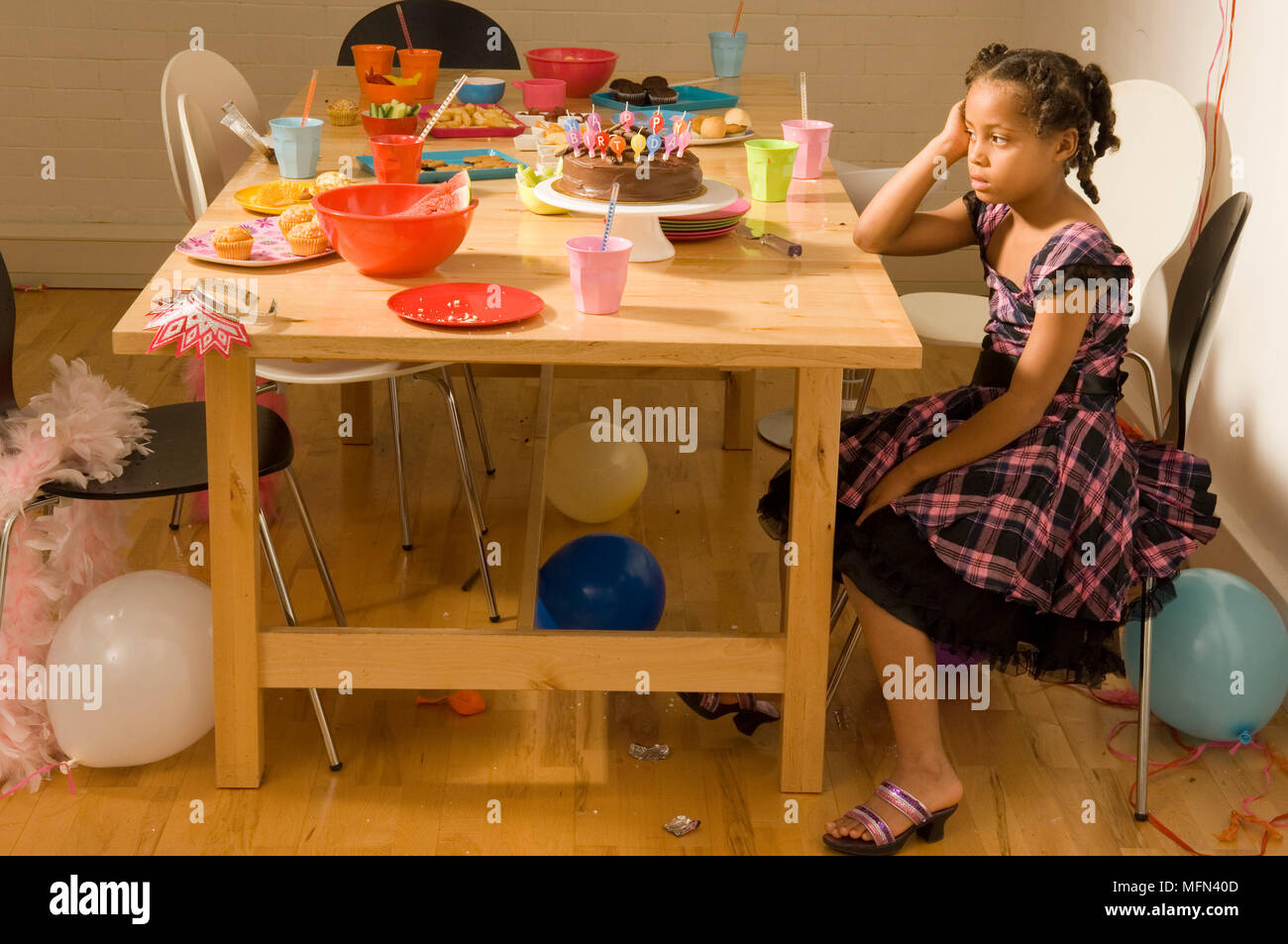 Side profile of a girl sitting on a chair at a birthday party and ...
