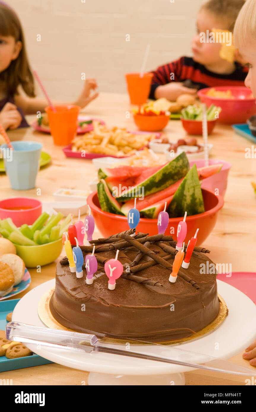 Close-up of a cake on the table with children sitting in the background ...