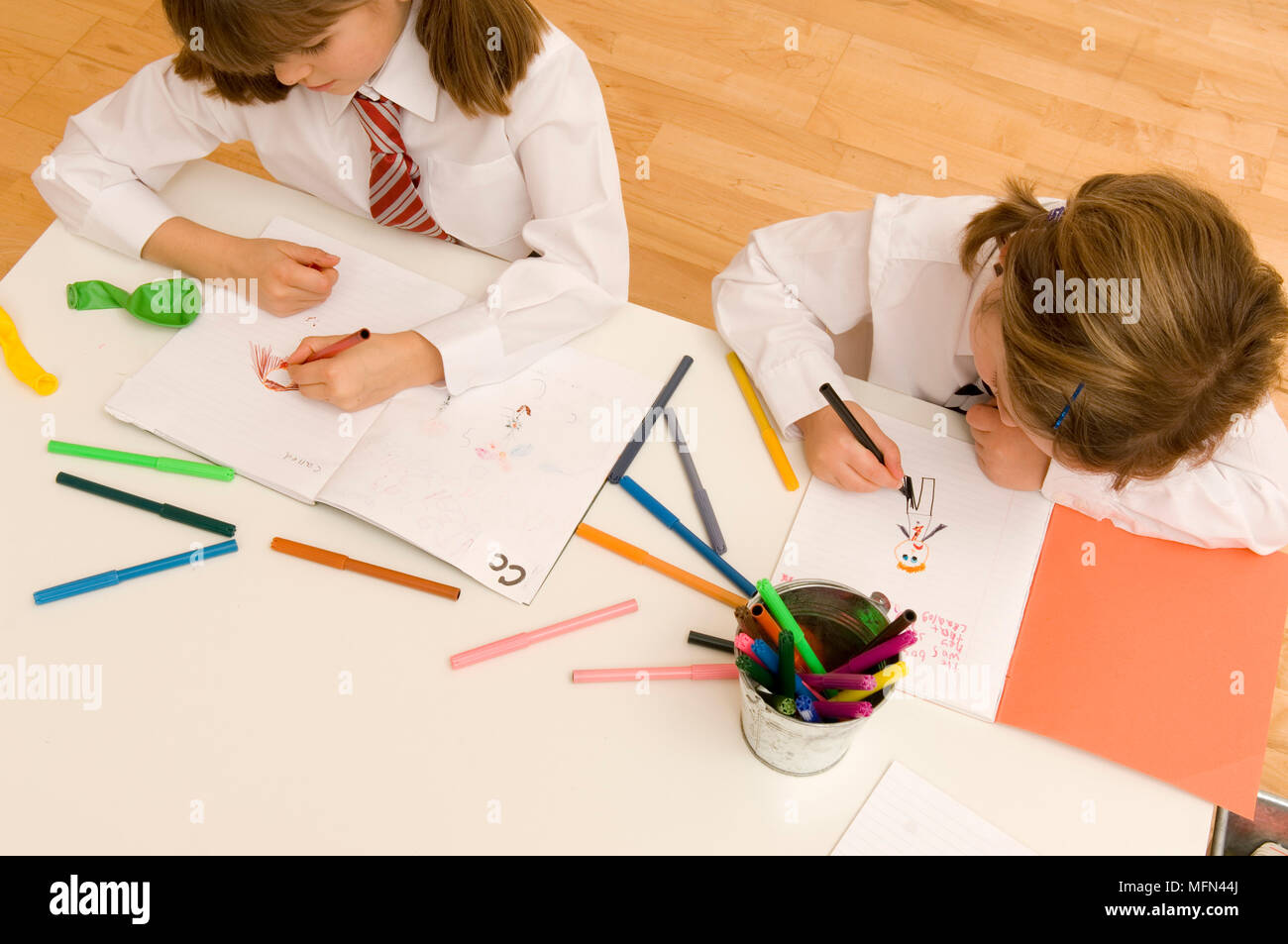 High angle view of two girls drawing with felt tip pens Ref: Compulsory ...