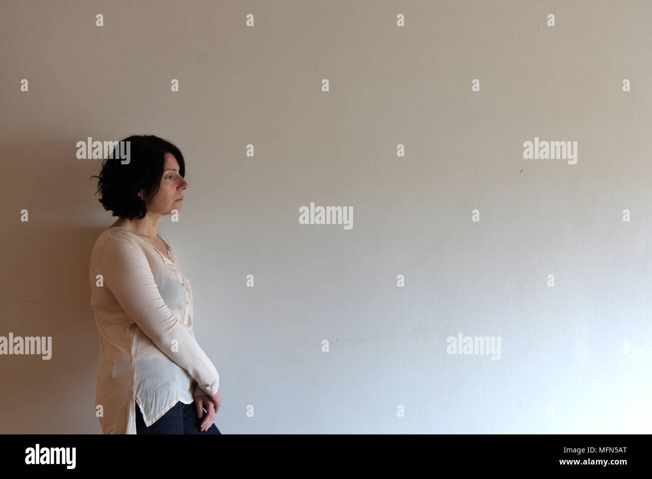 woman who is sad standing and slammed into the wall Stock Photo - Alamy
