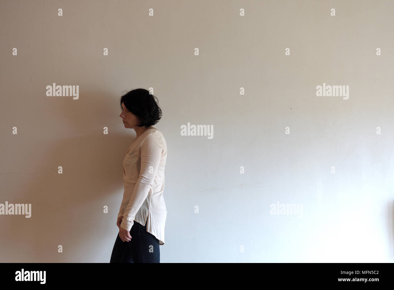 woman who is sad standing and slammed into the wall Stock Photo - Alamy