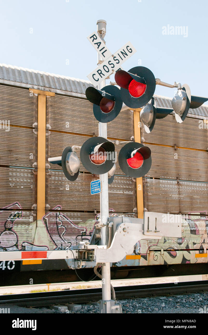 Graffiti tagged train speed through train crossing Stock Photo - Alamy