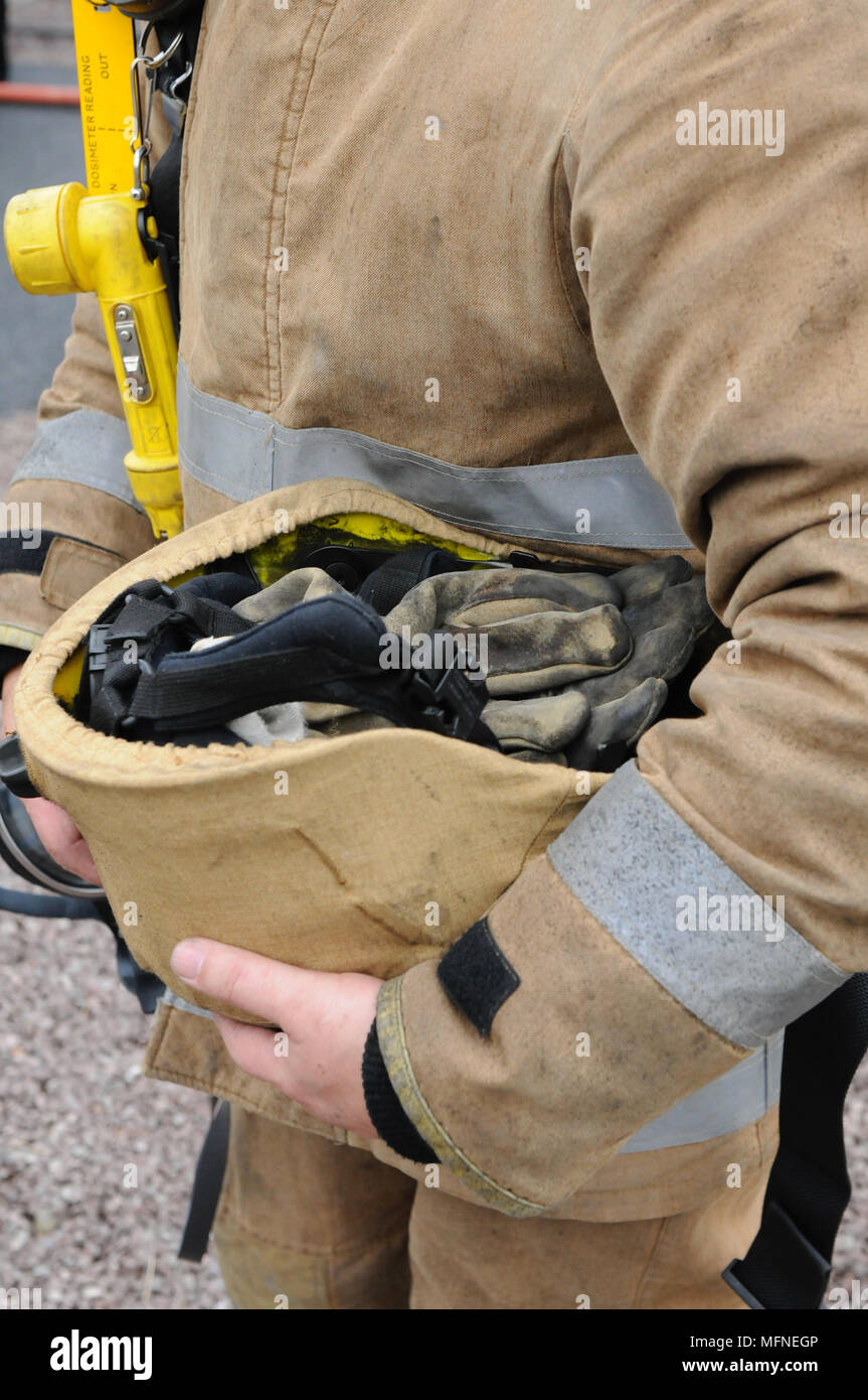 Fireman on a fire training ground donning breathing apparatus for an ...