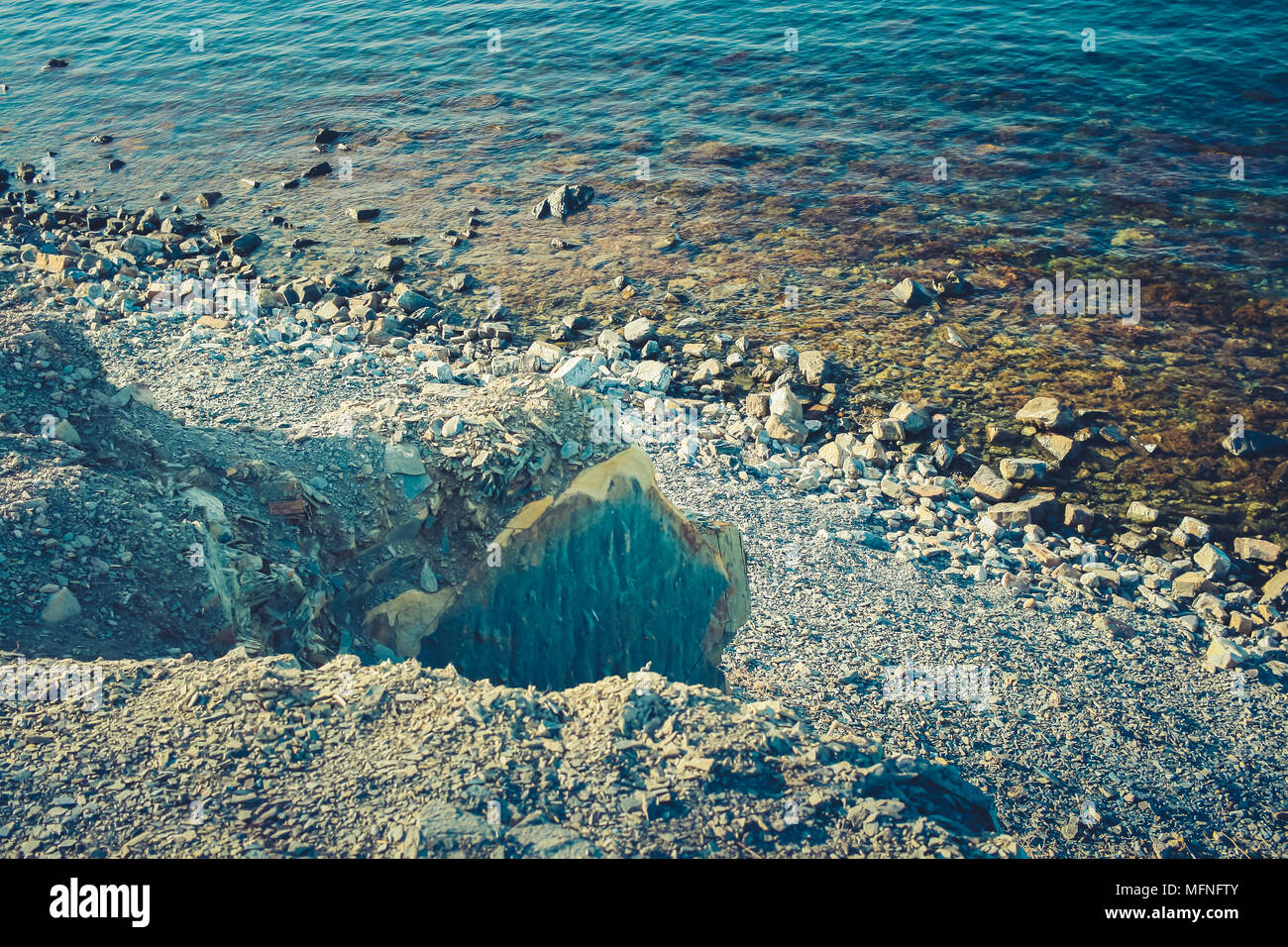 Fantastic stony, toned in blue, seashore with a quiet surf Stock Photo ...