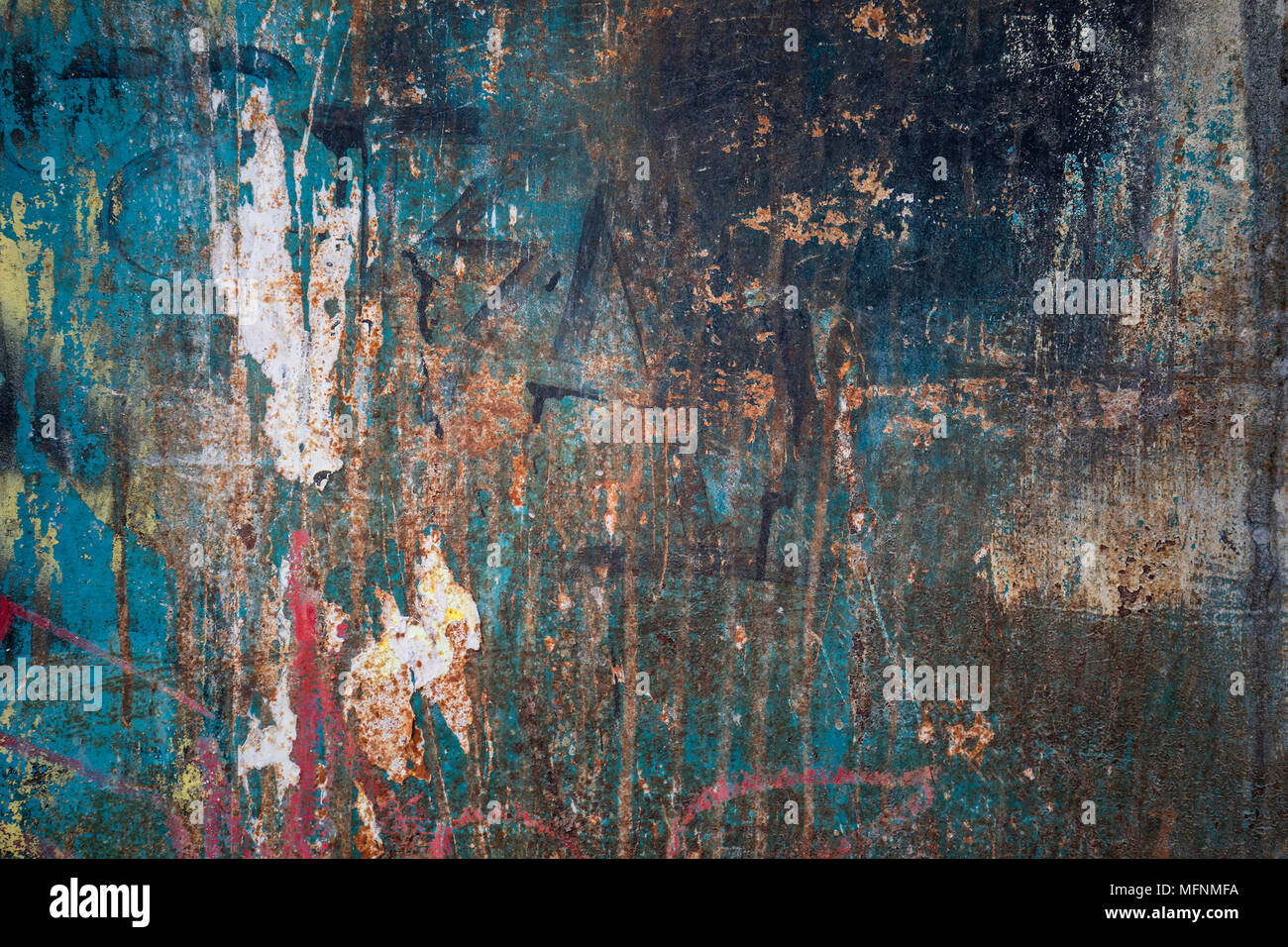 An abstract photograph of a metallic surface stained in light blue, red ...