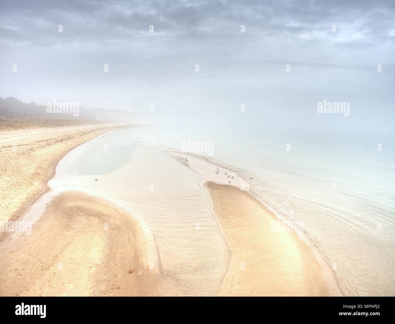 Beautiful misty sunrise on the German ocean coast. Heavy mist flowing ...