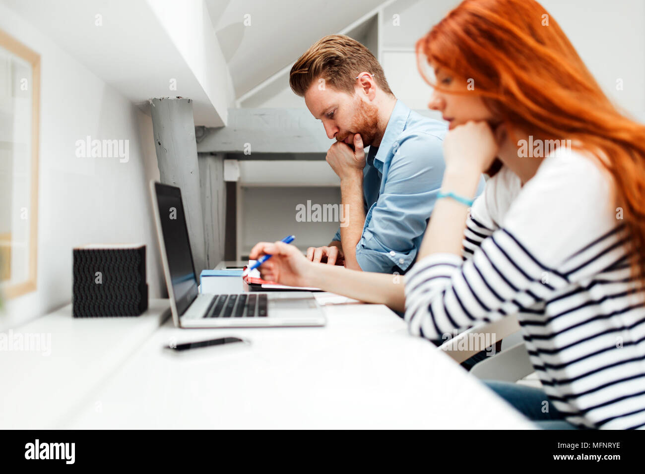 Colleagues working studying in white office Stock Photo - Alamy