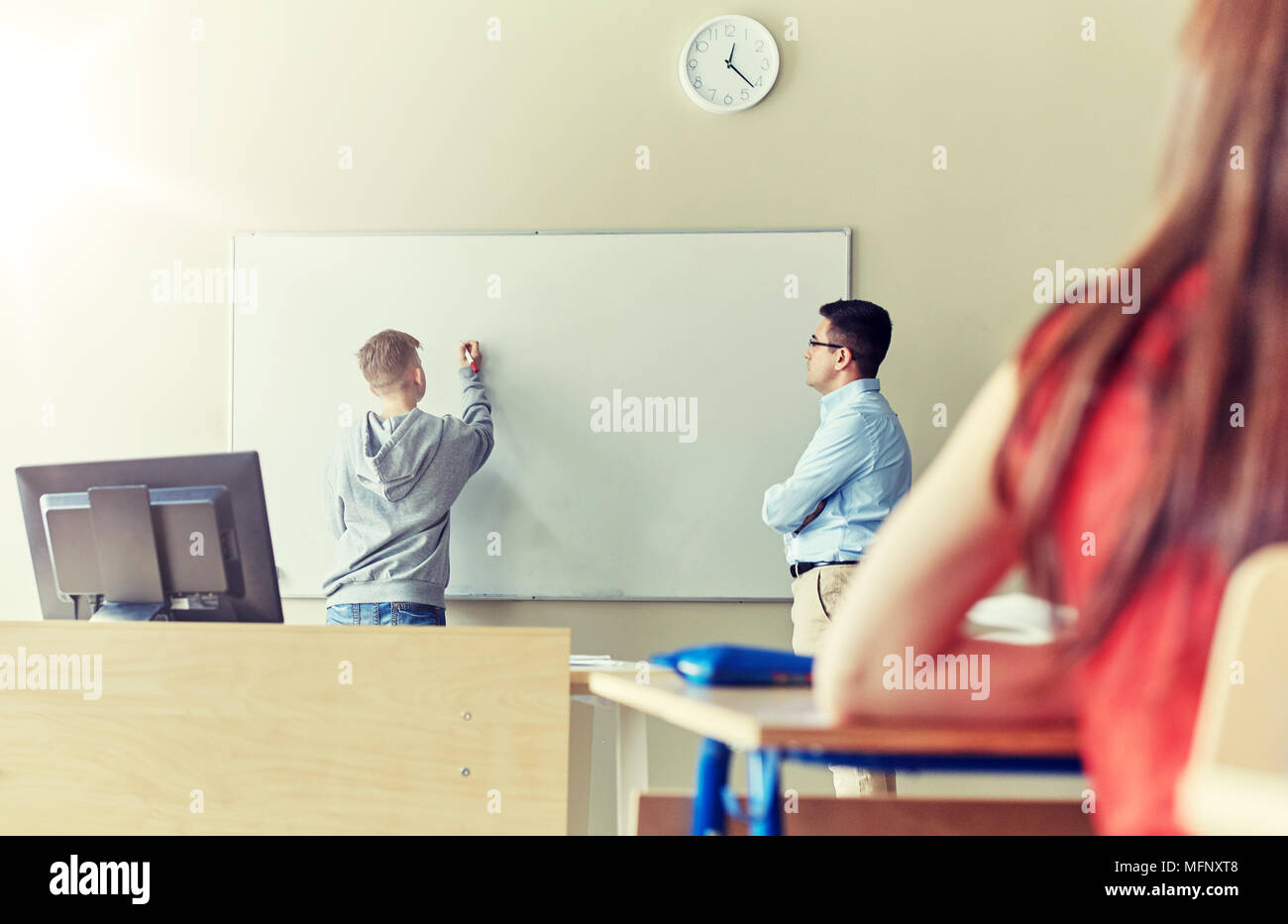 teacher and student writing on board at school Stock Photo - Alamy