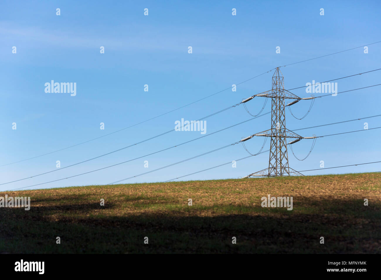 Tall electricty pylons with hanging wires carrying power to homes adn ...