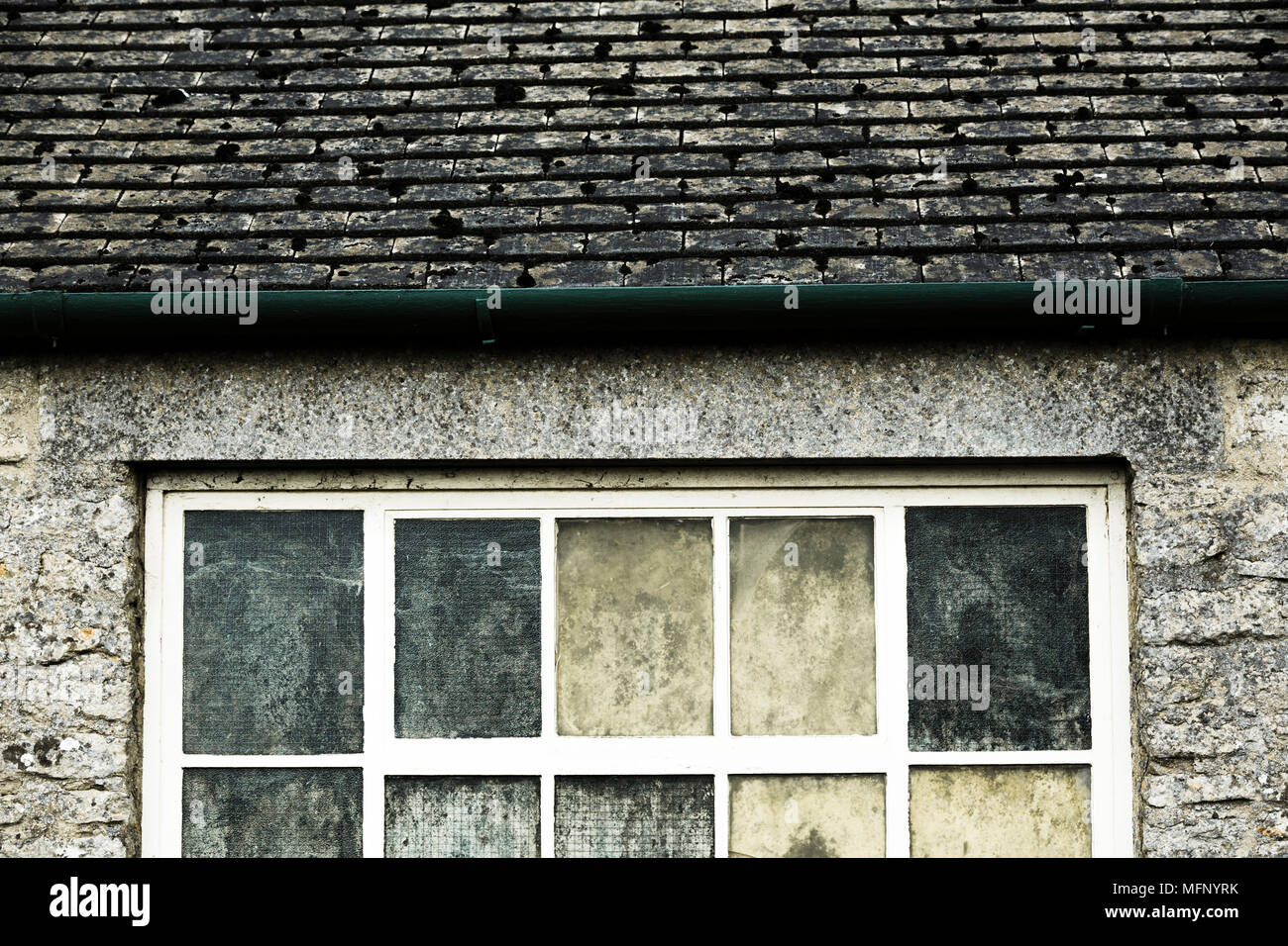 The side of an old weathered building with widnow adn peeling painted ...