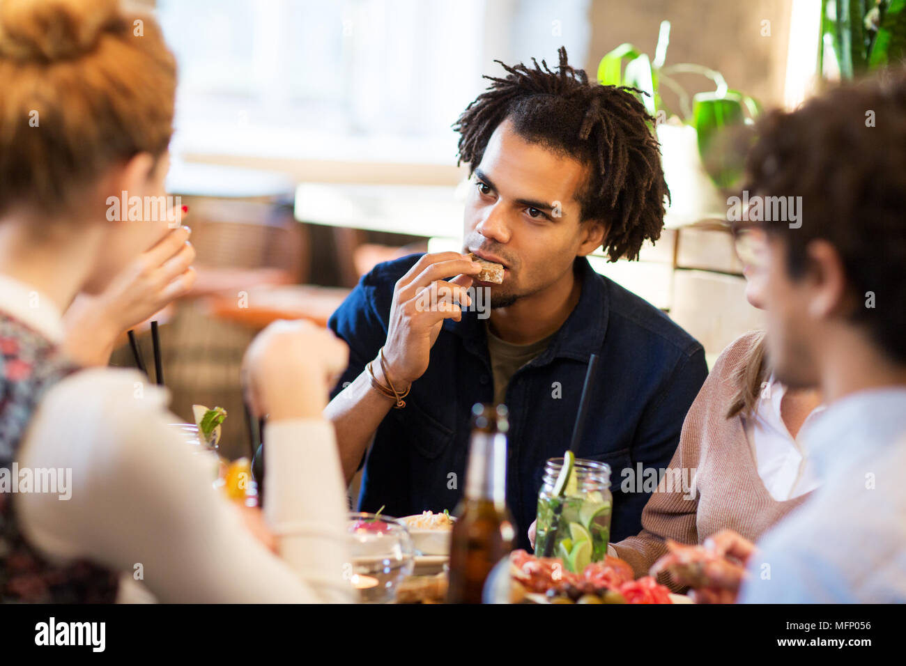 man with friends eating at restaurant Stock Photo - Alamy