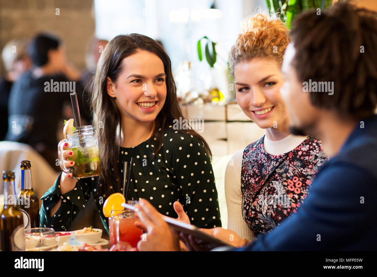 happy friends eating and drinking at restaurant Stock Photo - Alamy