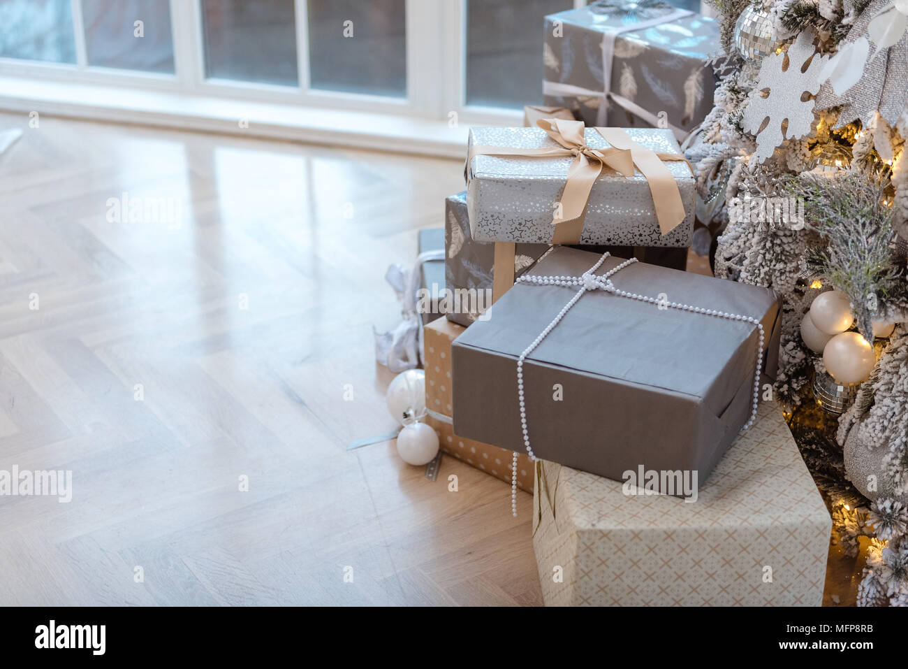 Gifts under the Christmas tree lights background Stock Photo - Alamy