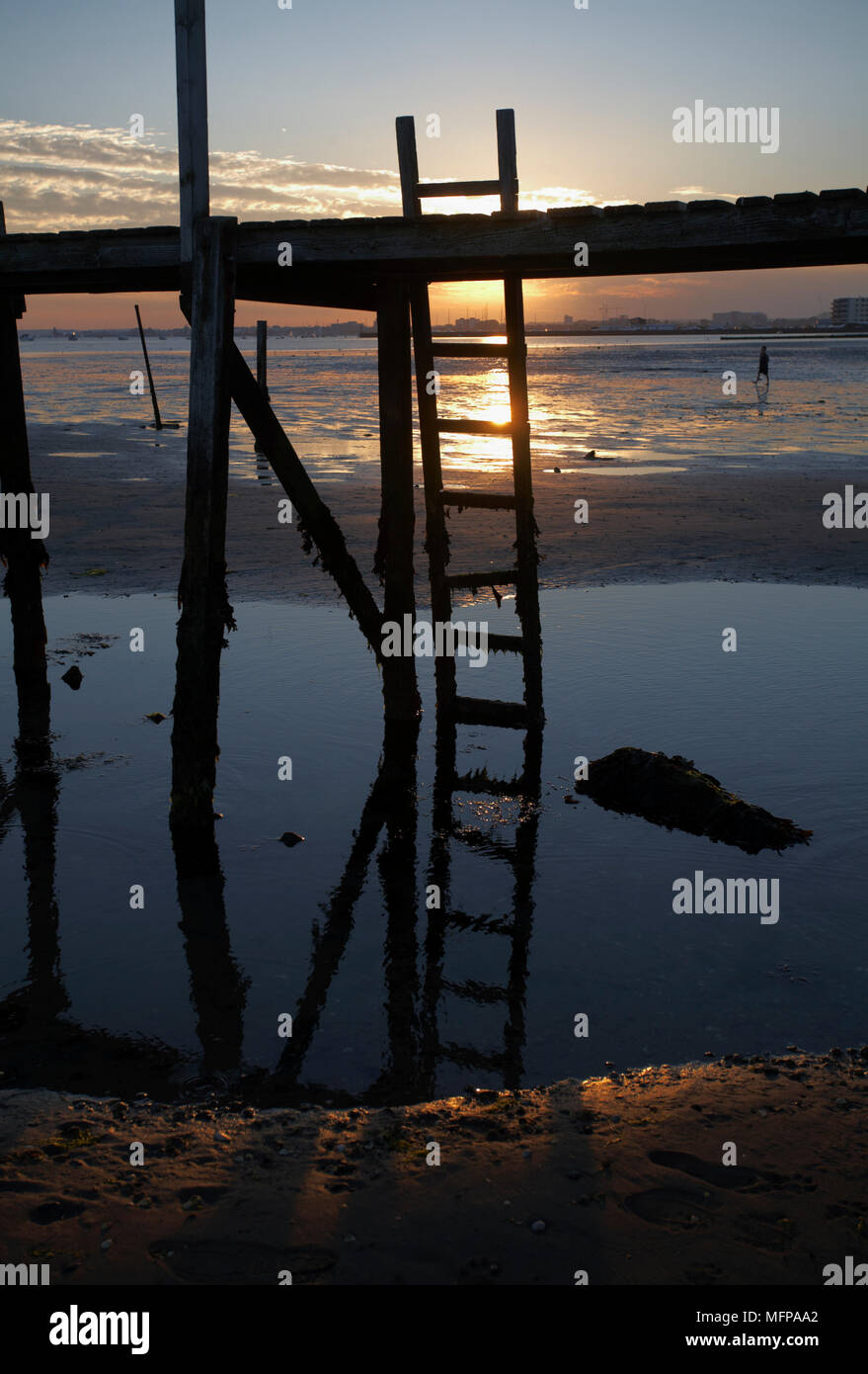 Reflections of jetty and ladder in the evening light at Poole Bay in ...