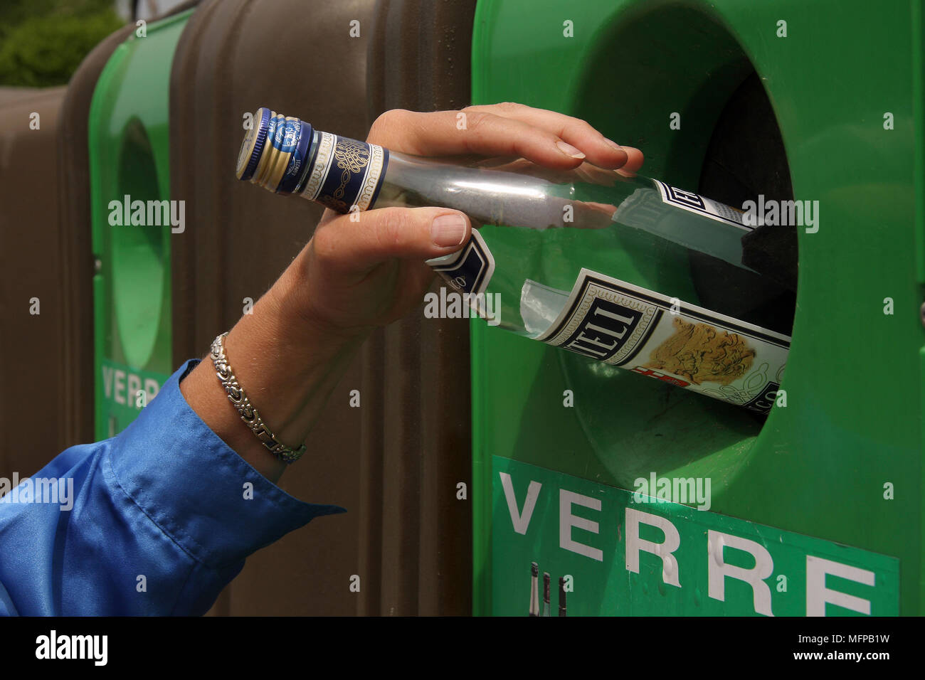 Close-up of a hand putting an empty bottle into a re-cycling bin Stock ...