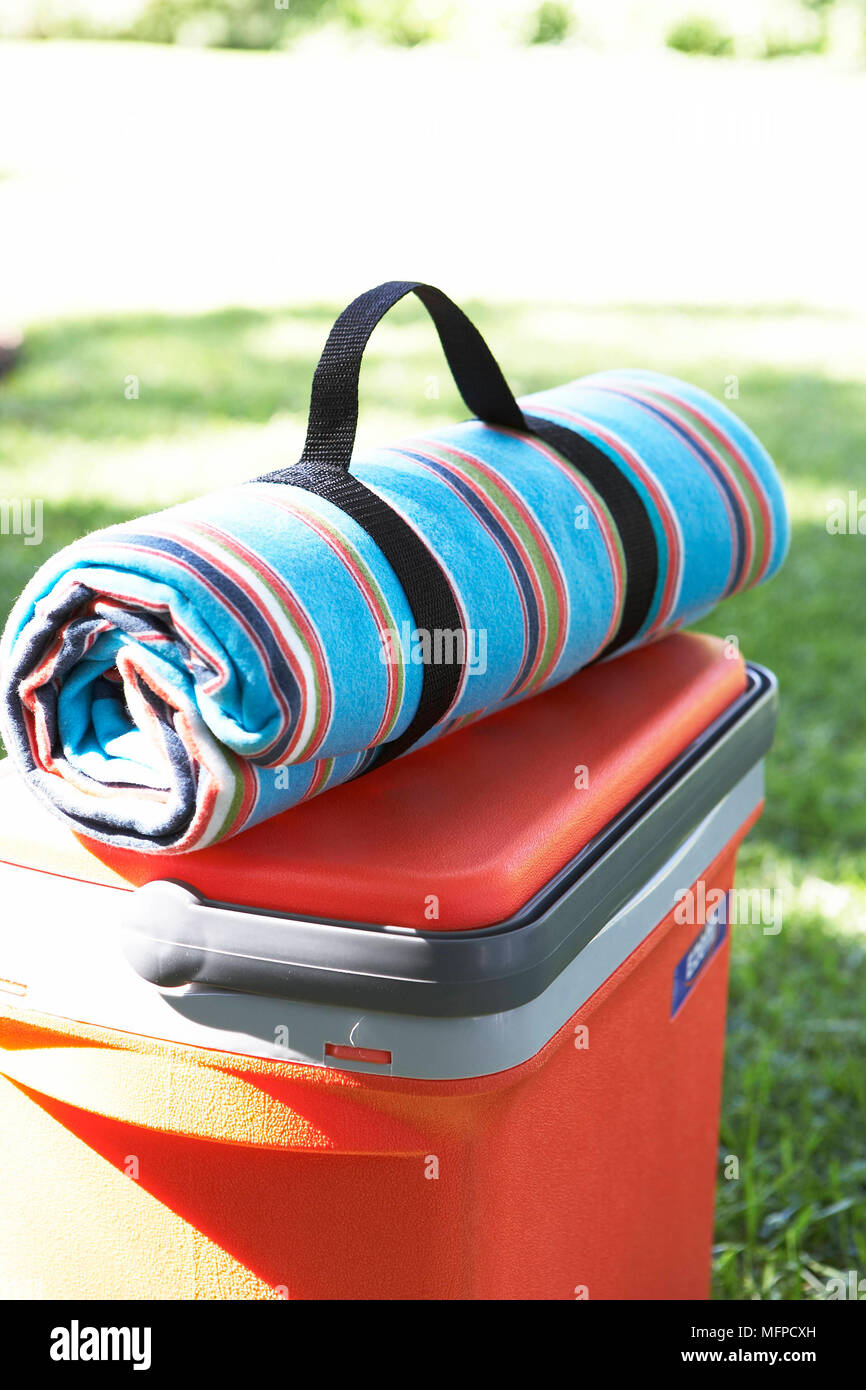 Rolled up portable beach mat on red coolbox Stock Photo - Alamy
