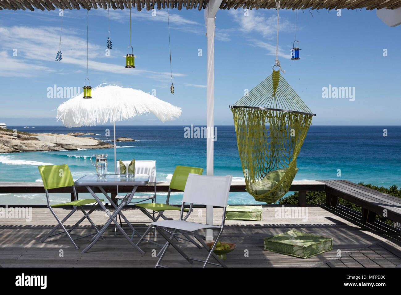 Table and chairs on decked terrace overlooking beach Stock Photo - Alamy