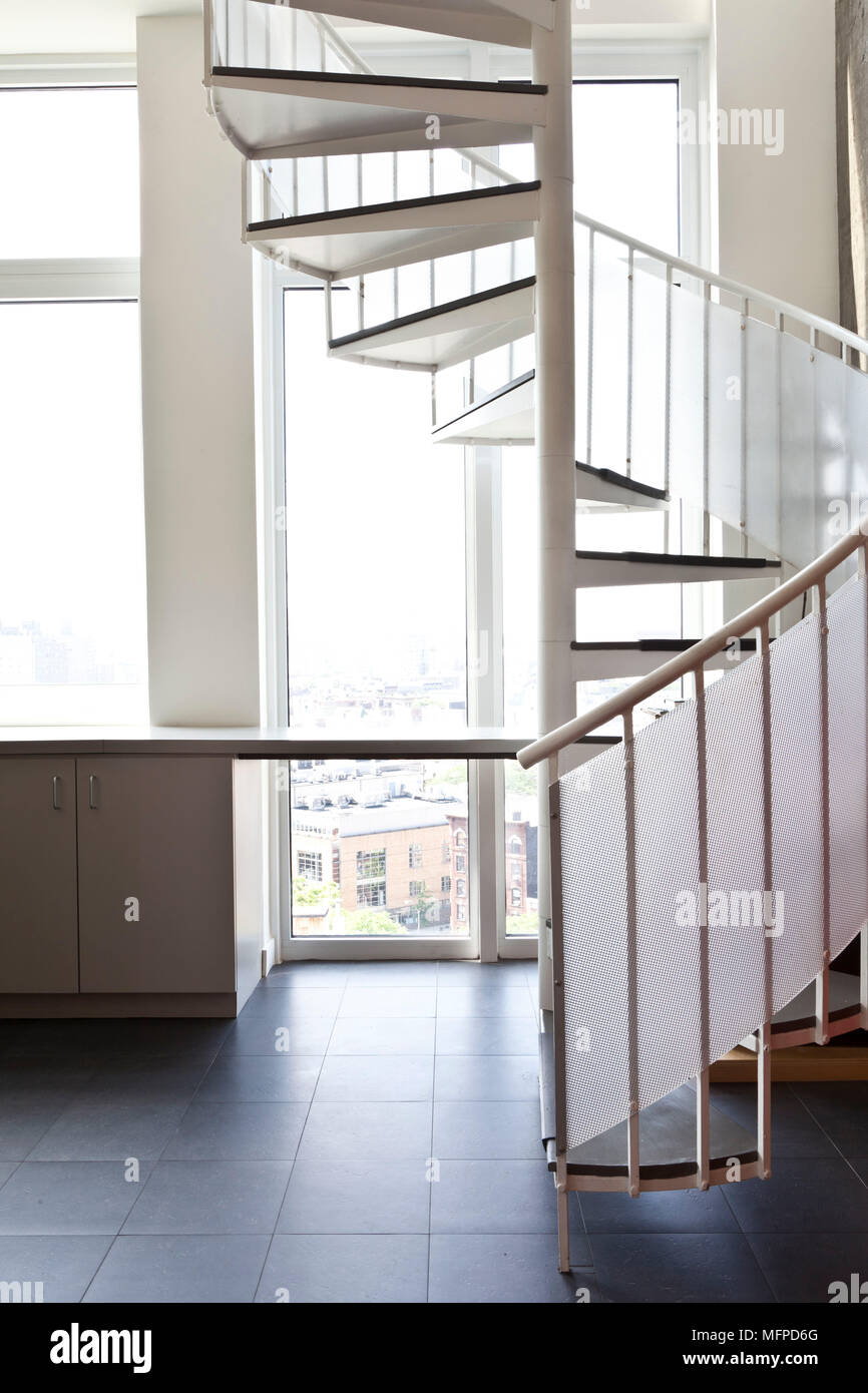 Spiral staircase leading up from modern kitchen, New York, USA Stock ...