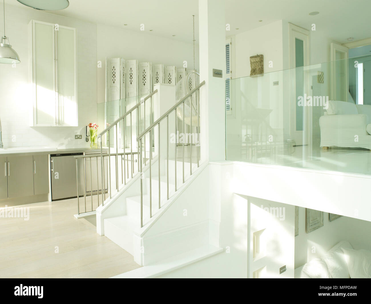 White contemporary open plan split level hallway with staircase to ...