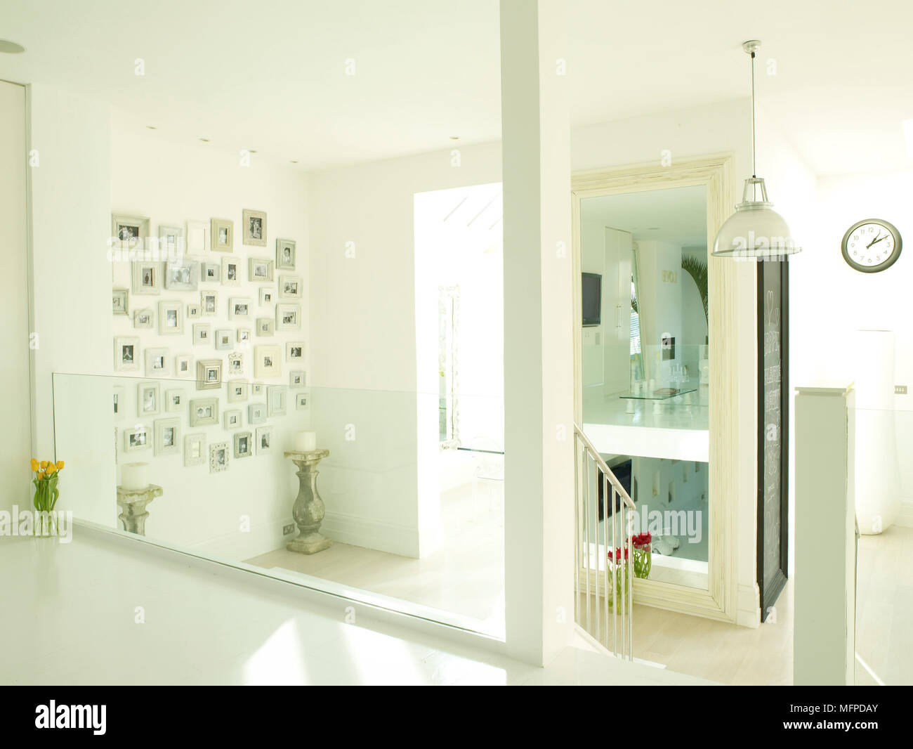 Display of photographs in contemporary white split level hallway Stock ...