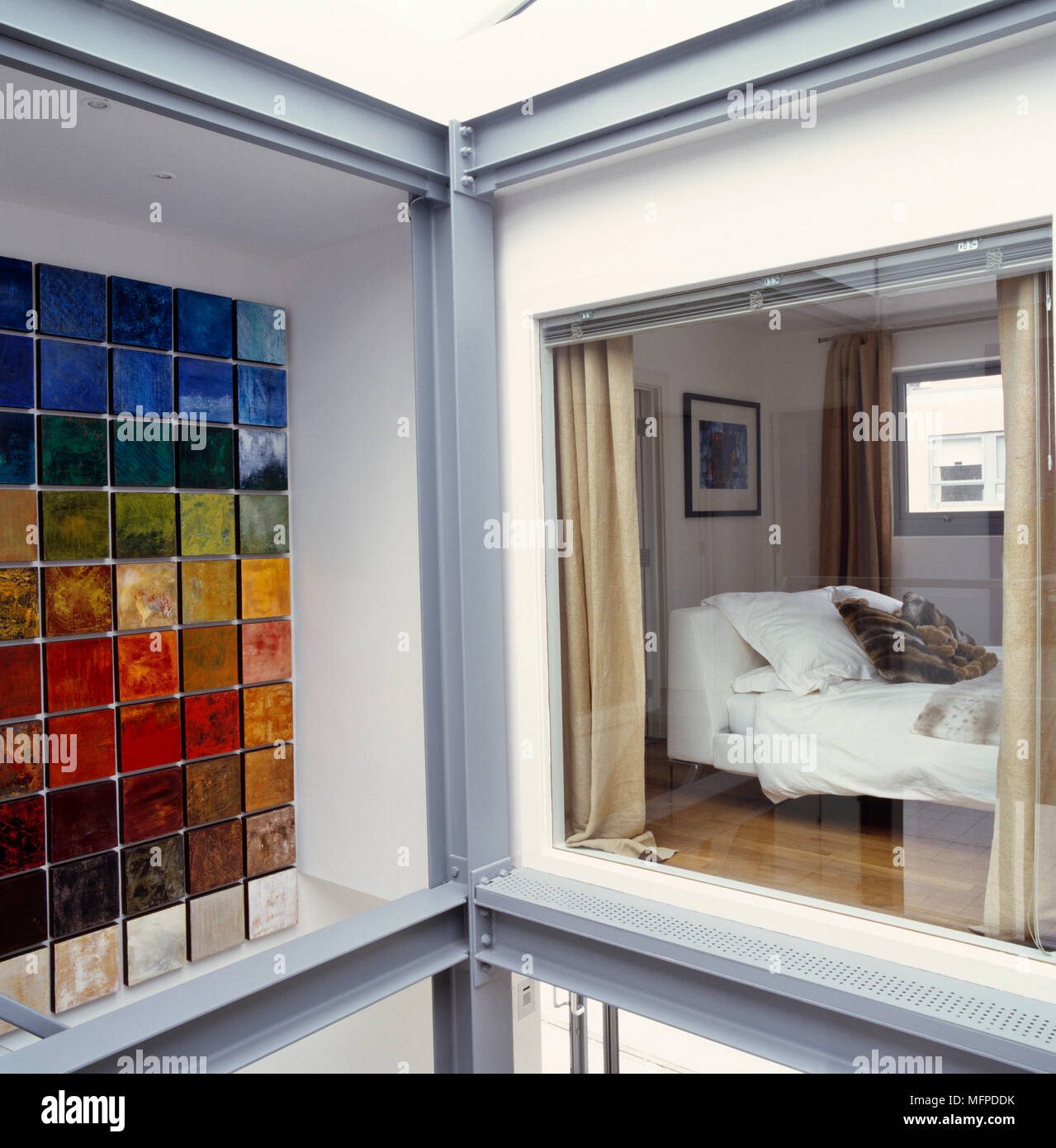Steel walkway under glass skylight with bedroom seen through window ...