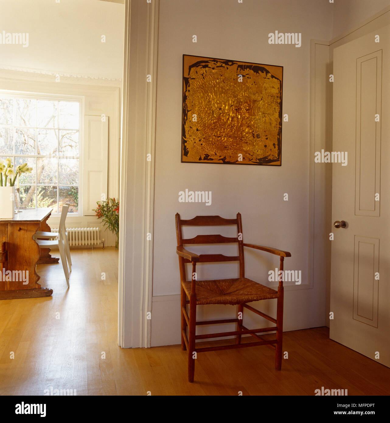 Country style chair against a wall with a picture above it Stock Photo ...