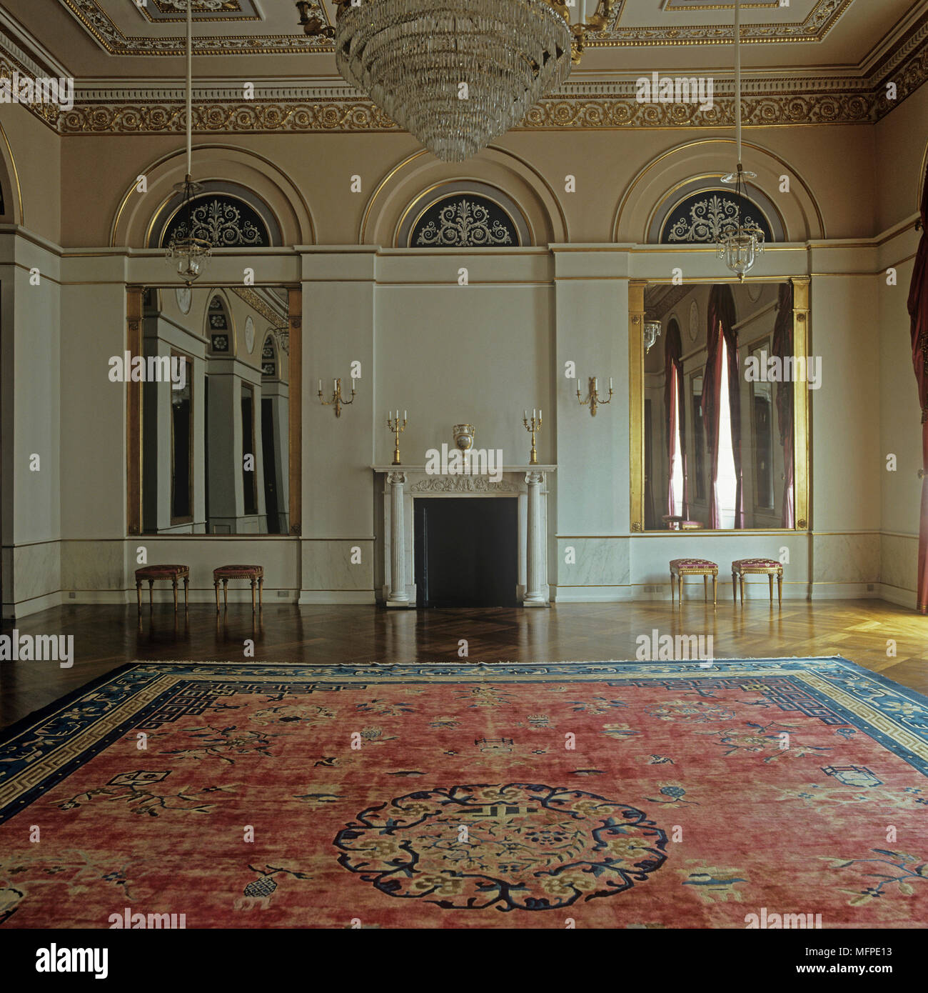 Grand hall with fireplace and gilded ceiling and ornate chandelier ...