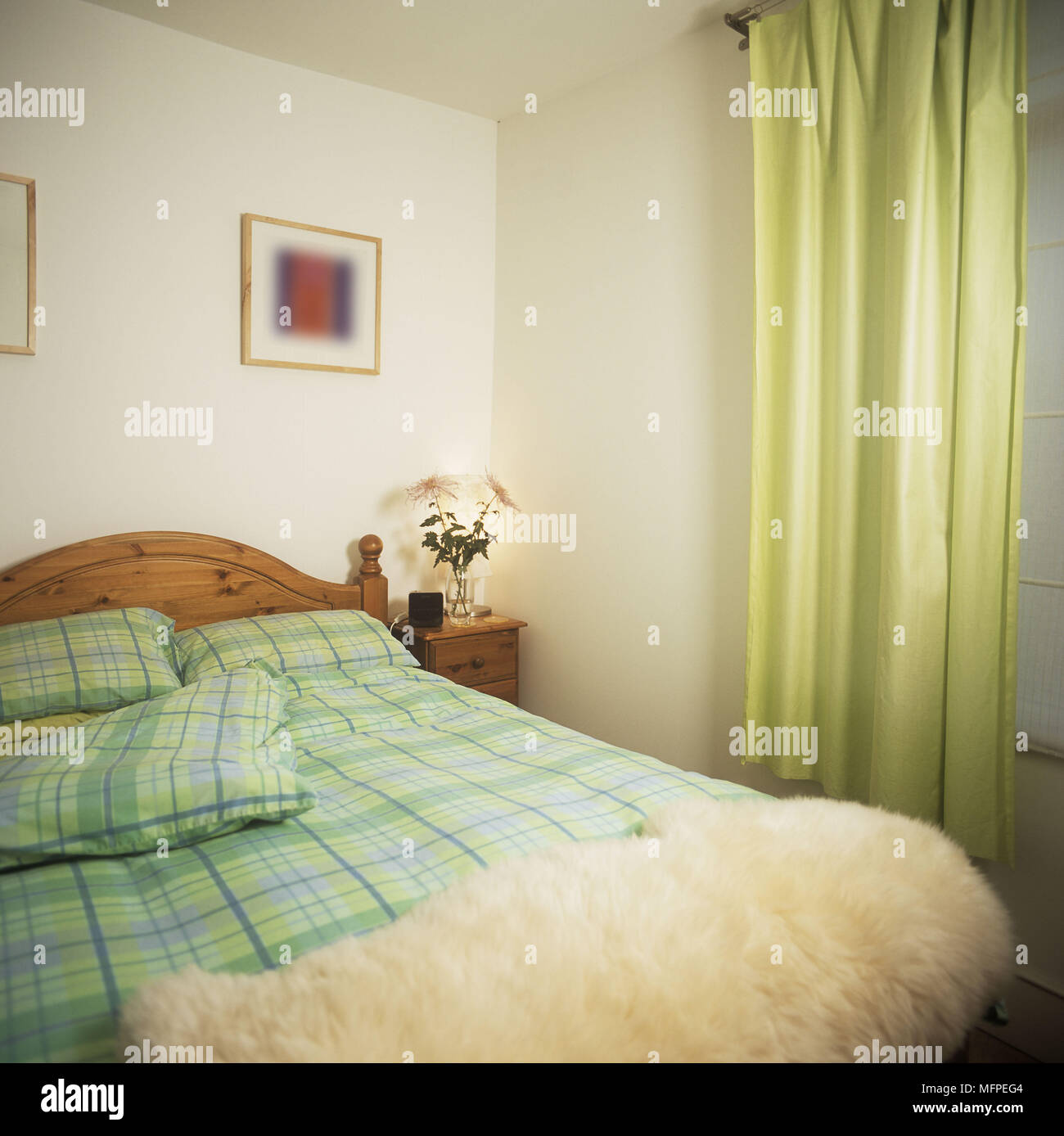 Modern bedroom wooden bed green and yellow check cover Stock Photo - Alamy