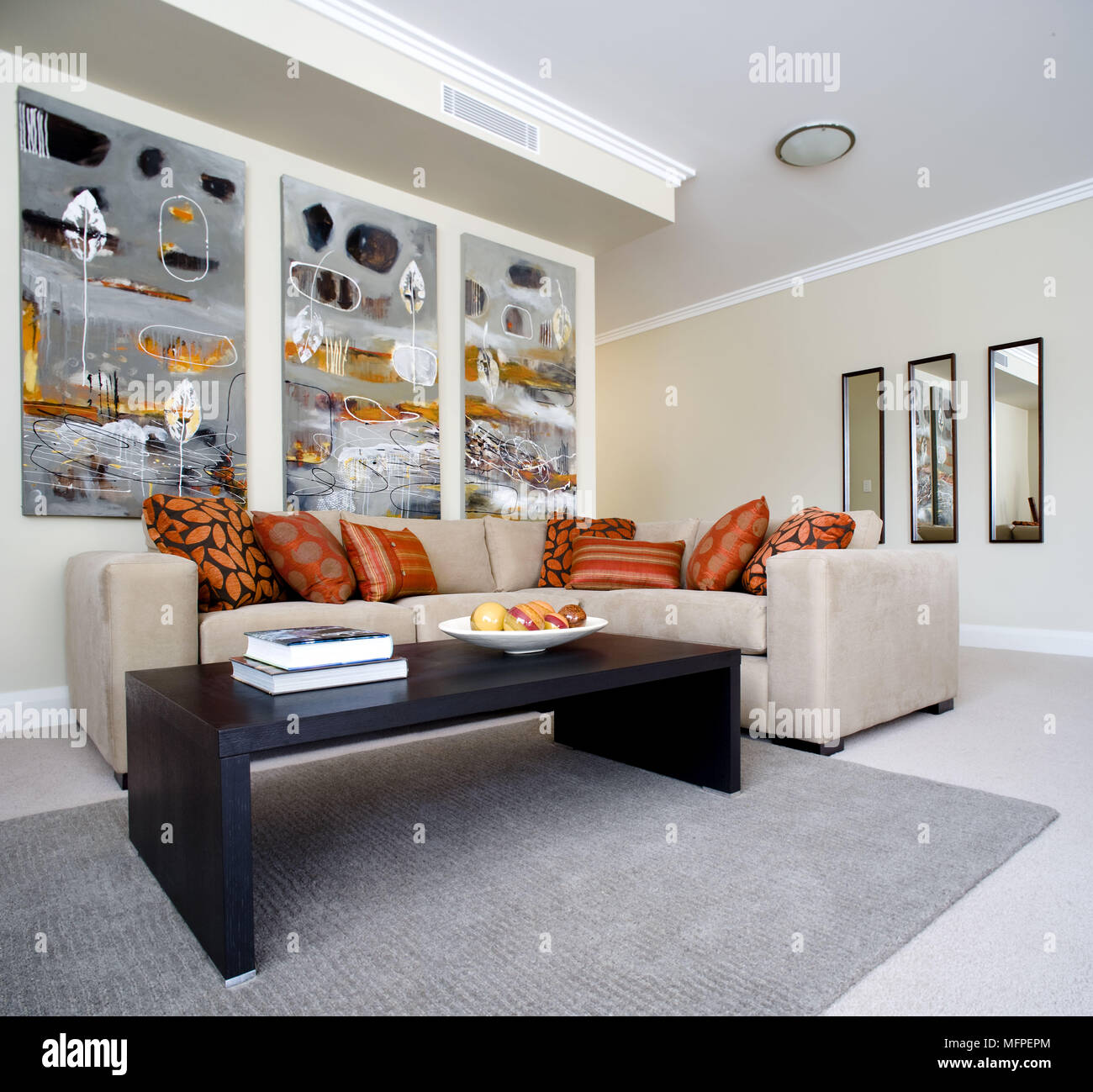 Black wood coffee table in front of upholstered sofa in modern sitting ...